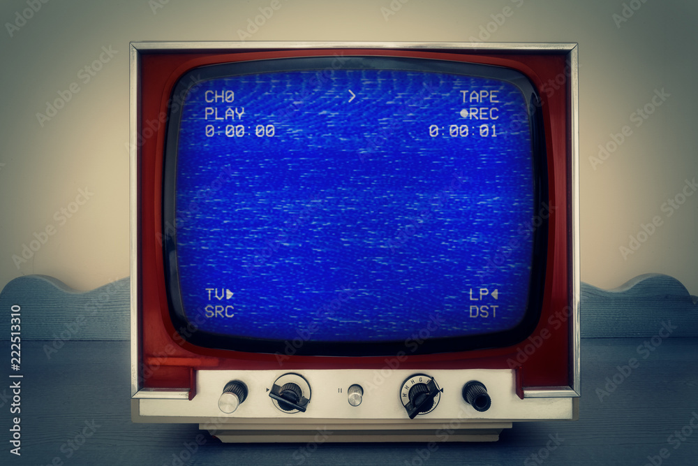 A retro vintage TV showing an old bad broken VHS tape playing. Blue ...