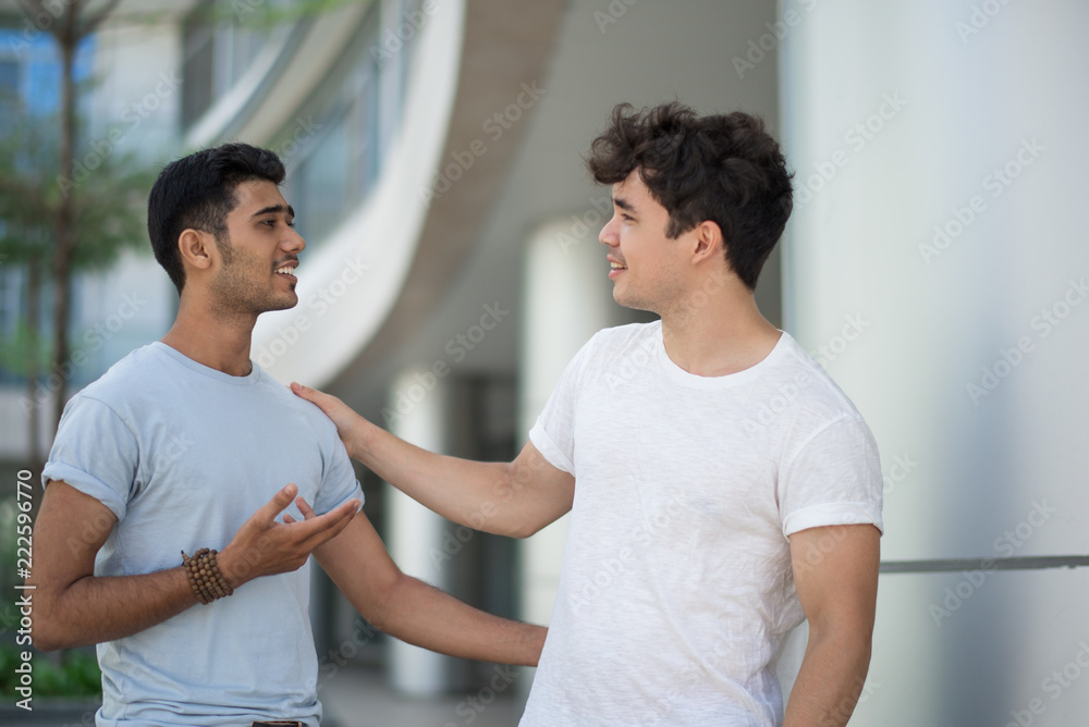 Positive handsome friends sharing life story while talking at modern ...