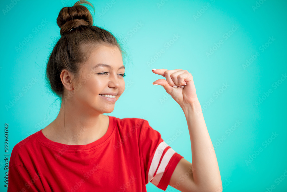 laughing awesome girl shows something invisible, isolated blue ...