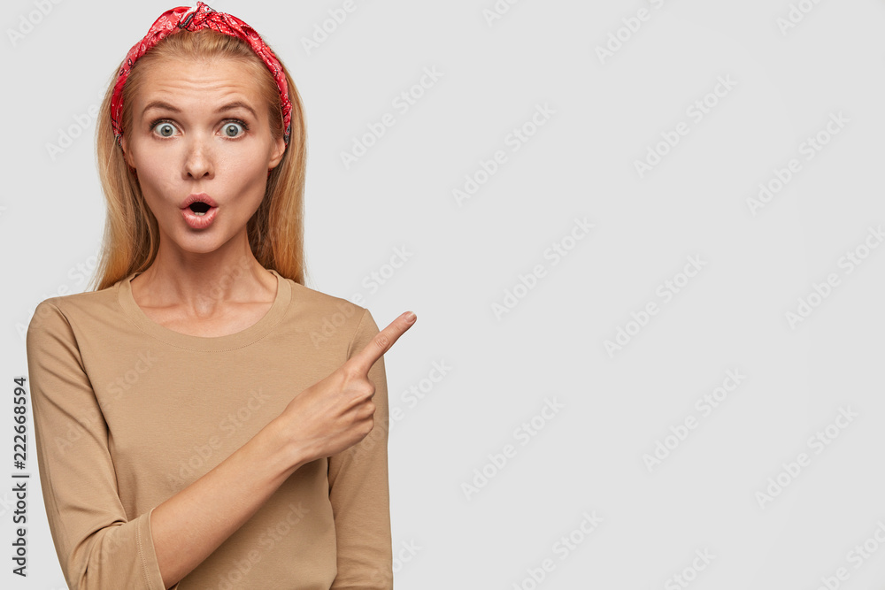 Image of surprised Caucasian woman with stupefied expression, points at ...