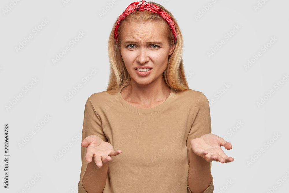 Desperate blonde woman frowns face in dicontent, has negative facial ...