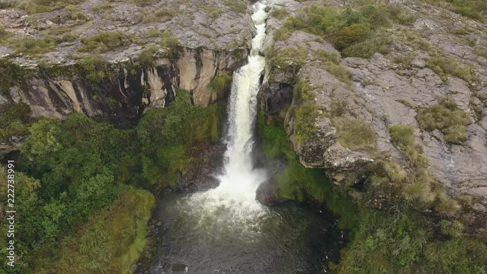 Slow motion aerial of a waterfall in the Rio Pita Valley near Cotopaxi ...