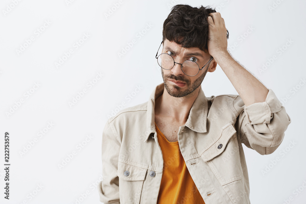 Foto de Waist-up shot of confused good-looking young man with beard and ...