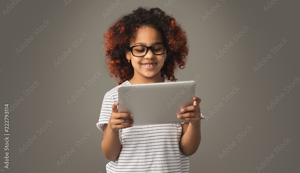 Cute black child girl using tablet ob studio background Stock Photo ...