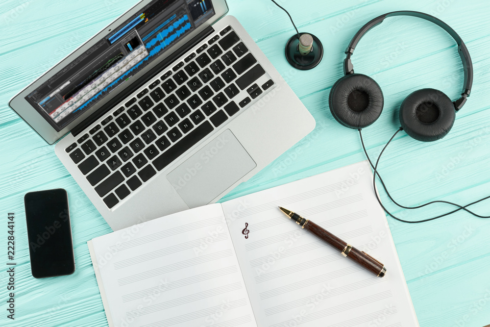 Desk with laptop, headphones and musical papers. Musician work space ...