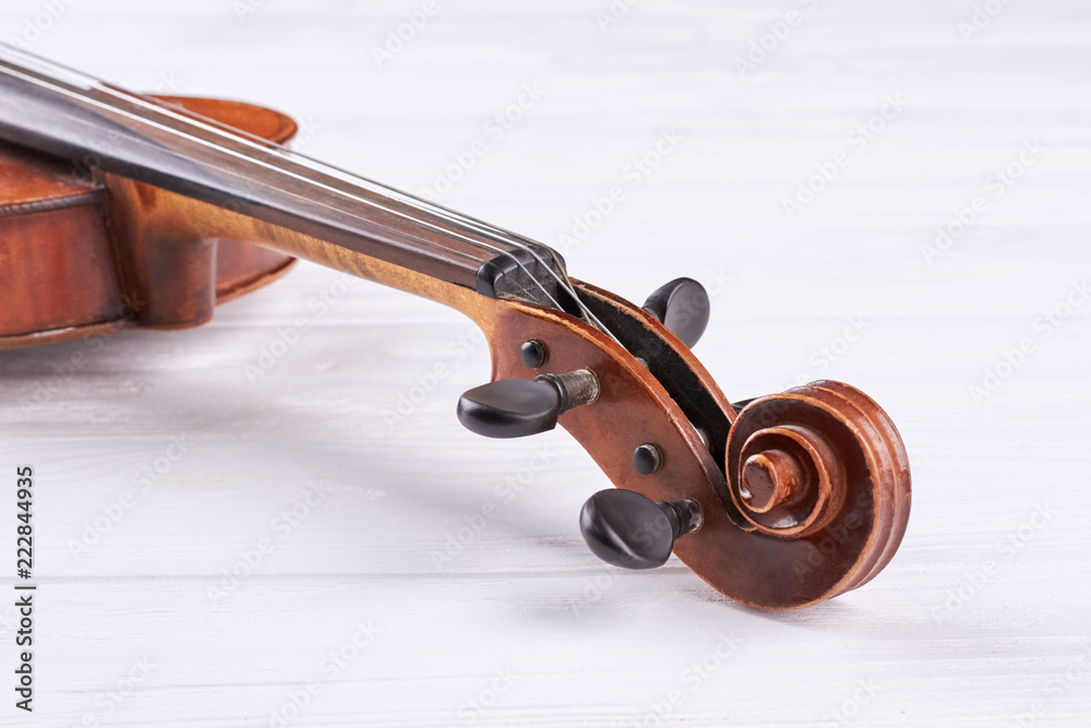 Violin scroll and peg box. Part of violin on white wooden background ...