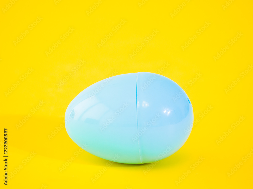 Close-up photograph of a light blue plastic easter egg on vibrant ...