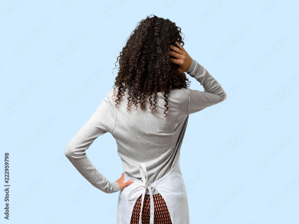 Young girl with apron on back position looking back while scratching ...