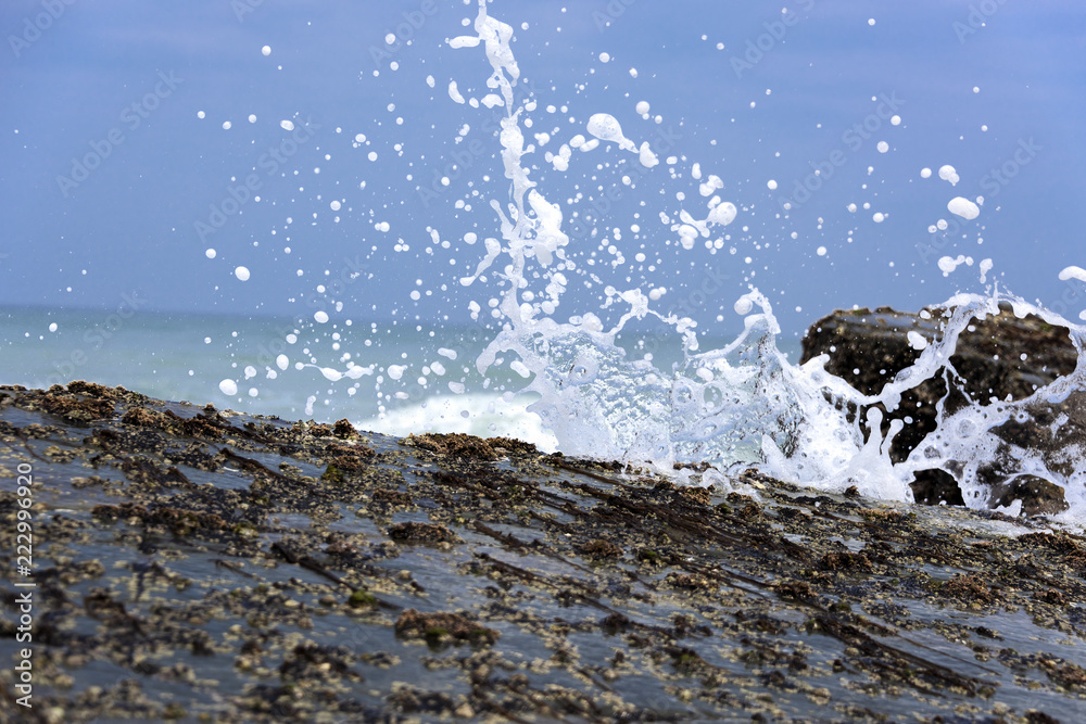 Ocean sea water splashes wild untamed against rocky coast cliff with ...