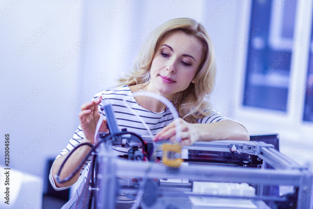 Technical support. Pleased young engineer leaning on printer while ...