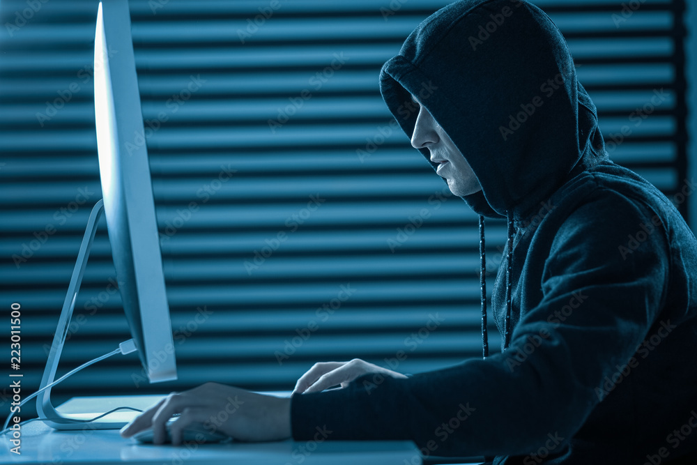 Secret information. Mysterious smart man in hood hacking secure system ...