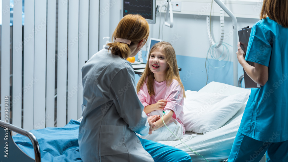 Cute Little Girl Sits on a Hospital Bed and Talks with Friendly Woman ...