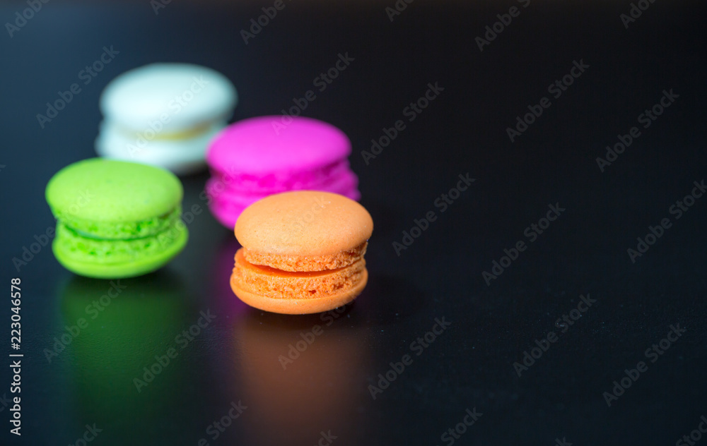 macarons on black floor and brick wall background. candy, bakery and ...
