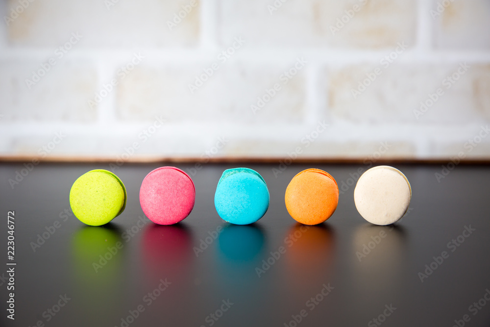 macarons on black floor and brick wall background. candy, bakery and ...