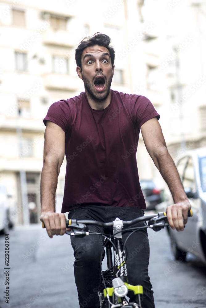 Young man lost control over his bicycle wheel, sliding downhill afraid ...