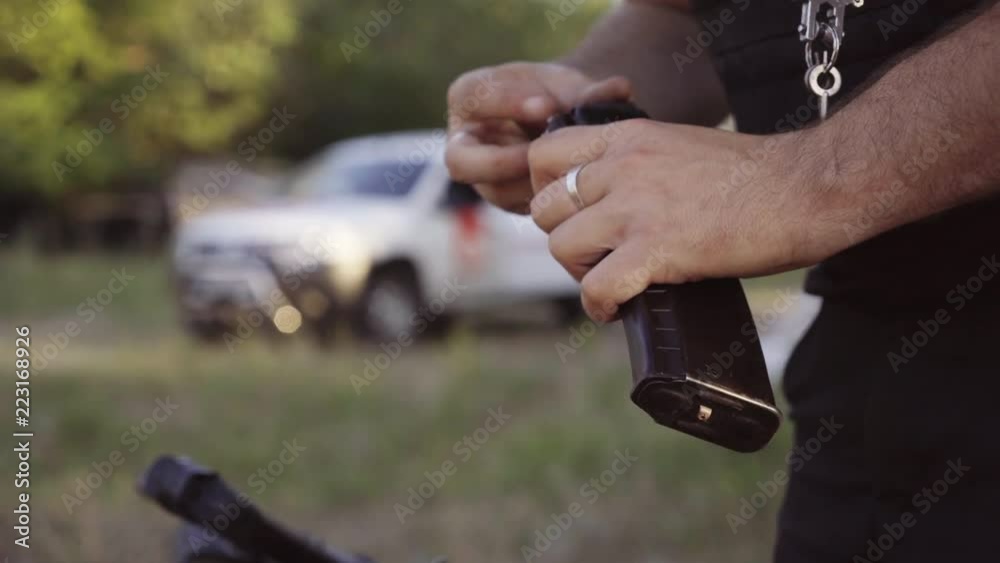 The security guard puts bullets into the magazine for machine gun and ...