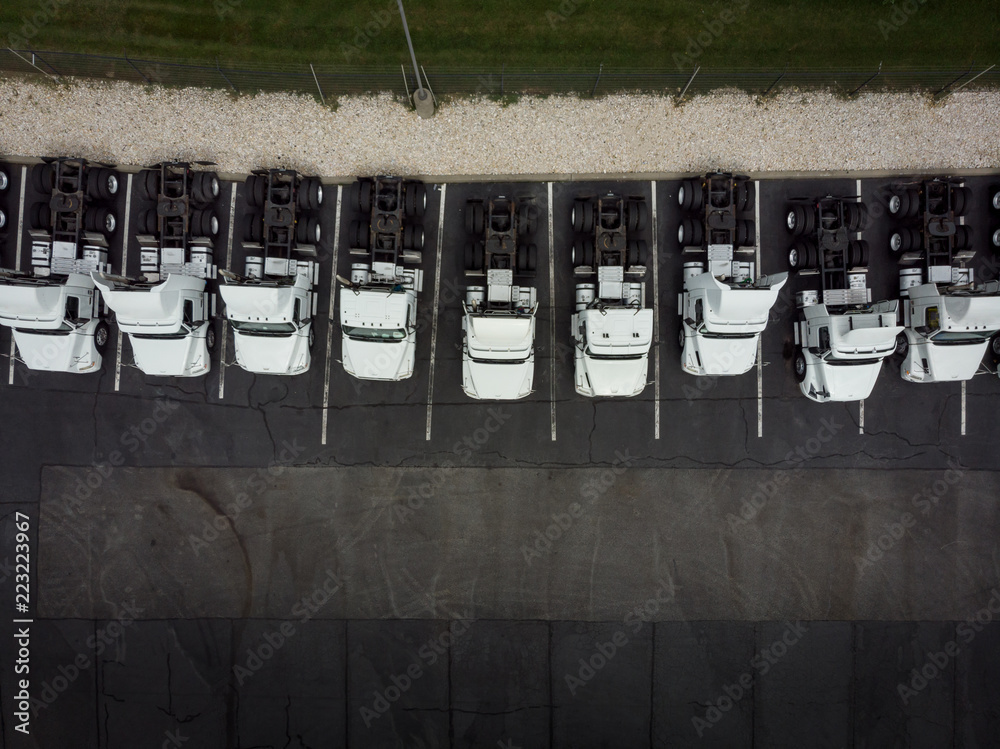 Fleet of white 18-wheeler semi-trucks overhead view drone photography ...