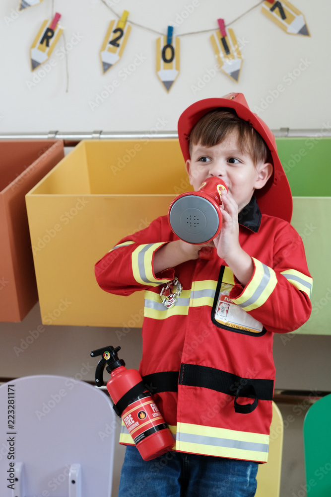 Boy playing as fireman police occupation in kindergarten class, kid ...