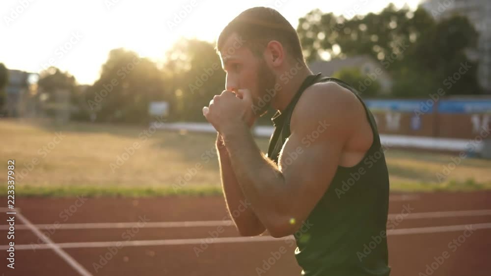 Bearded, concentrated man boxer doing boxing exercise, warming up while ...