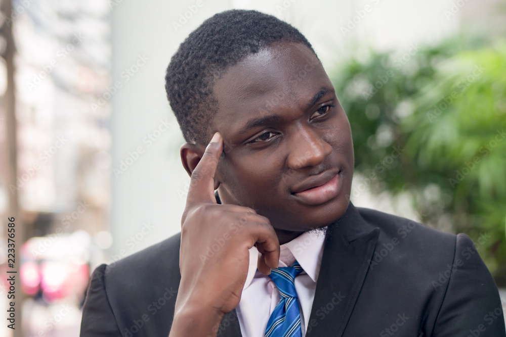 confident african or black businessman thinking; portrait of confident ...