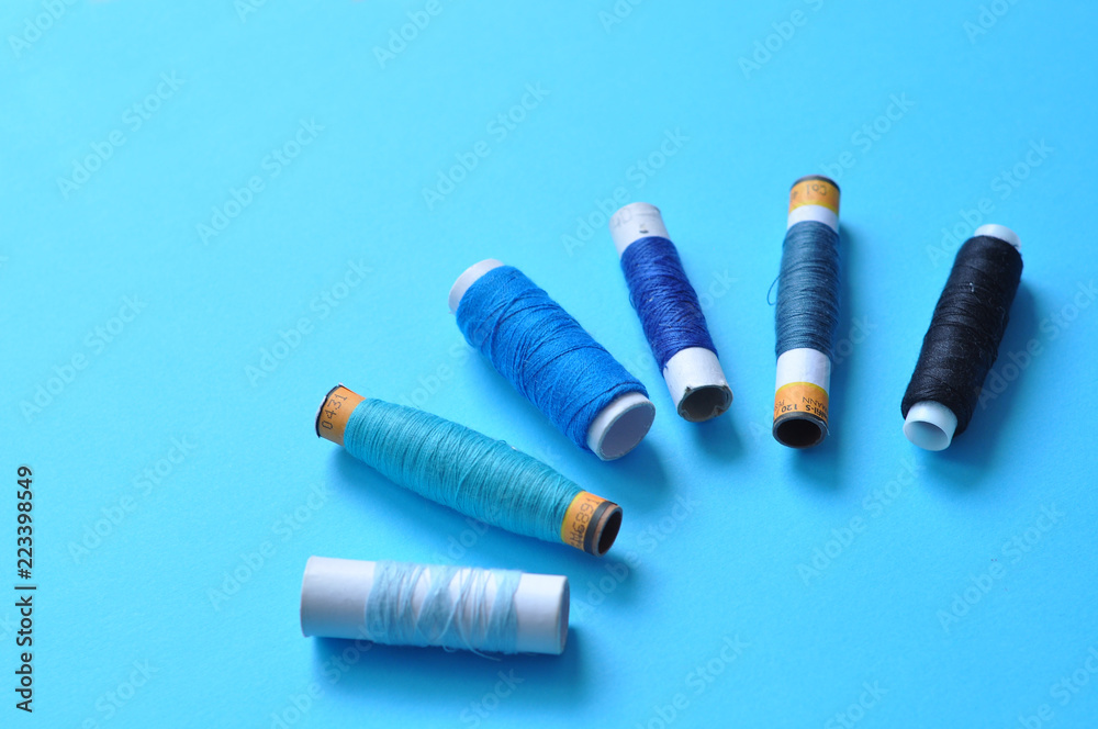 blue thread reels for sewing on a blue background. photo thread on ...