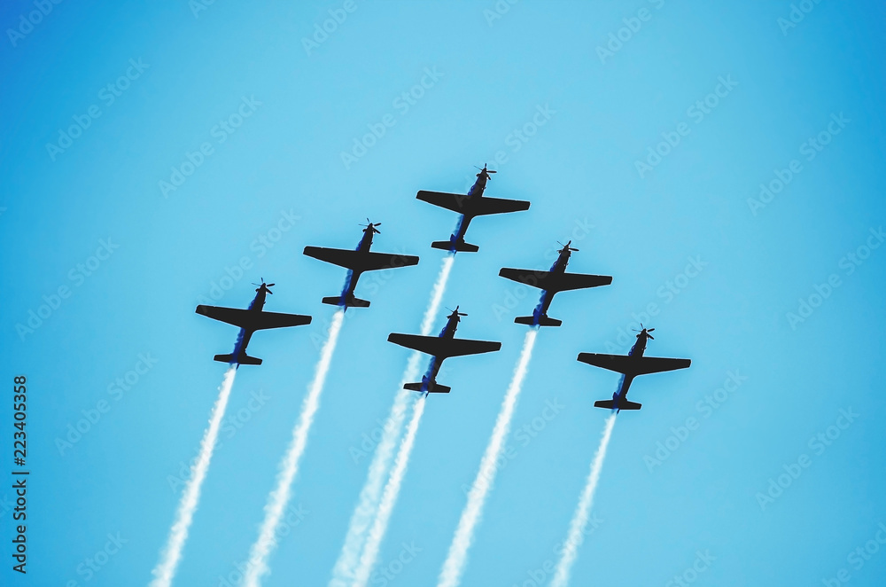 Squad of six airplanes flying together leaving a smoke trail behind ...