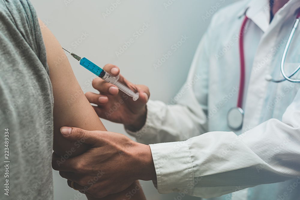Doctor giving vaccine vial dose shot drug using the syringe,treated by ...