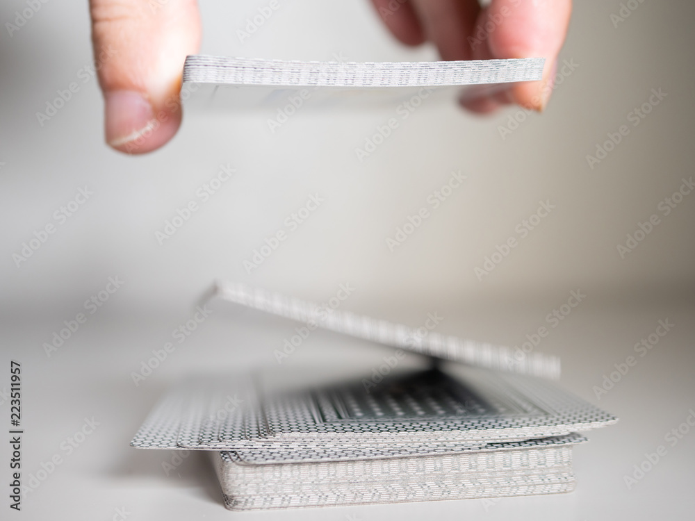 Hand shuffling cards on isolated white background. First person point ...