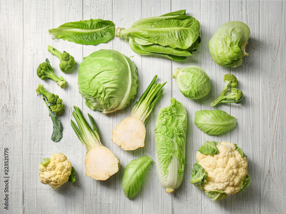 Different types of cabbage on light wooden background Stock Photo ...