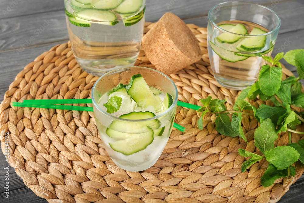 Glasses of fresh cucumber water on wicker mat Stock Photo | Adobe Stock