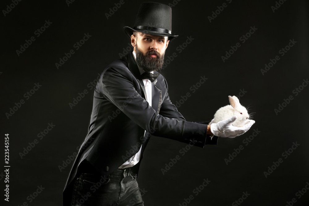 Magician with rabbit on dark background Stock Photo | Adobe Stock