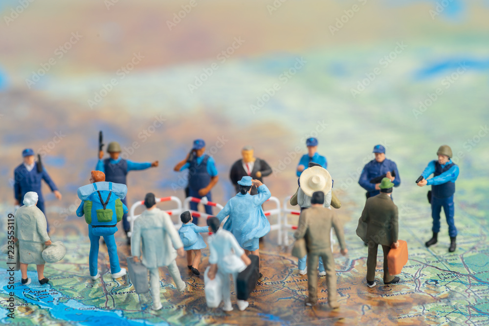 Miniature toy people concept US border patrols against a group of ...