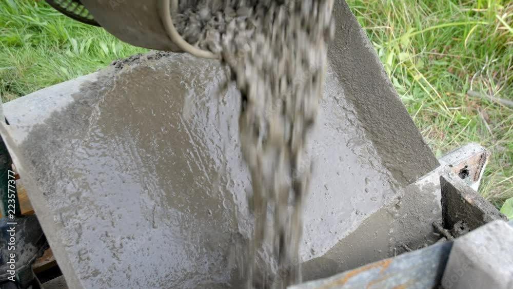 Concrete pouring. Construction worker mixing mortar. Pouring concrete ...
