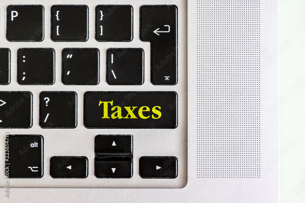 top view isolated laptop keyboard with yellow "taxes" text on button ...