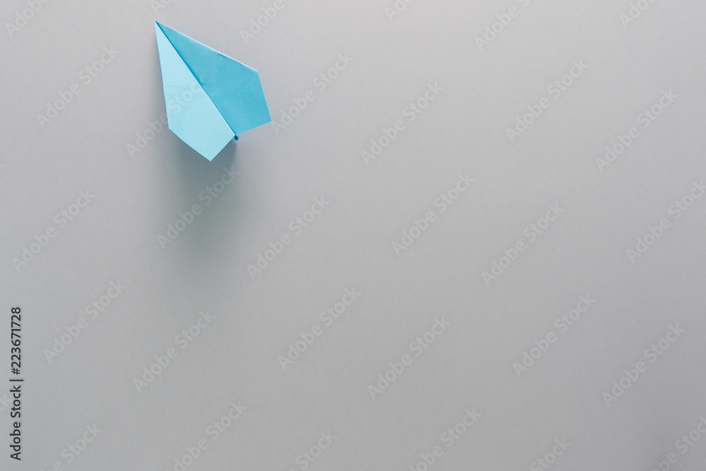 One flying paper plane over the grey background. Back to school and ...
