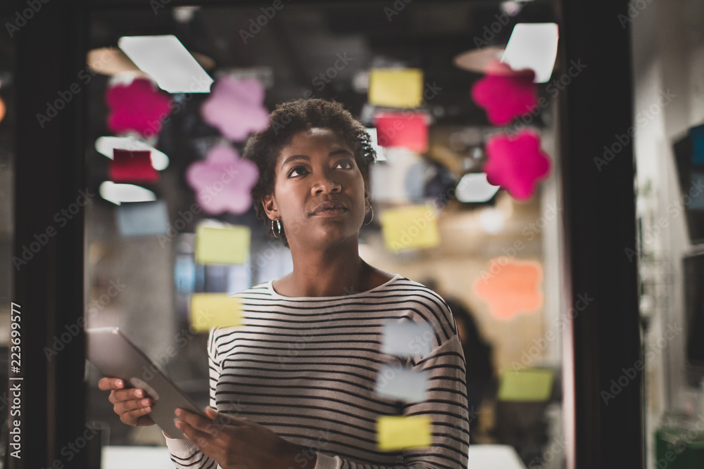 African American female brainstorming ideas at night in an office Stock ...