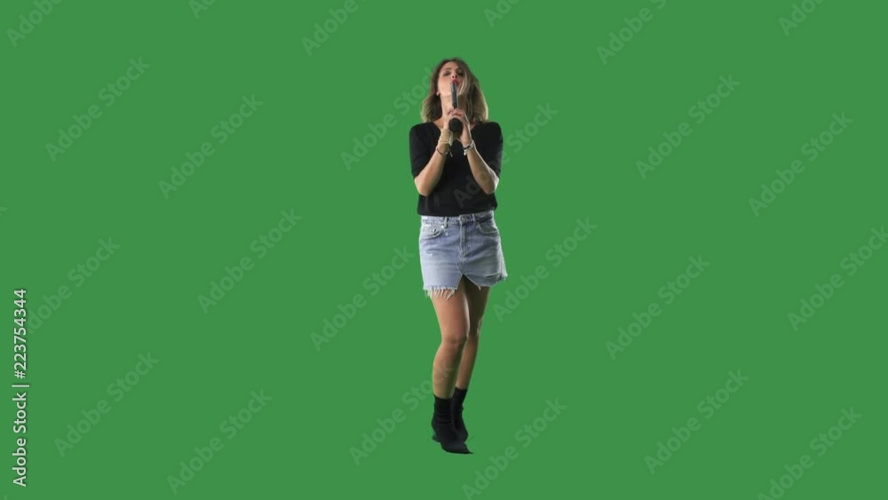 Back view of woman turning at camera and shooting a weapon. Full body ...