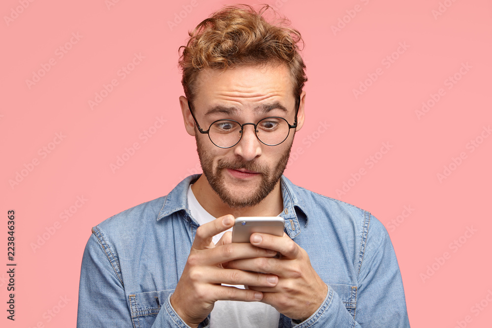 What does it mean? Clueless surprised handsome European guy looks with confusion at camera ...
