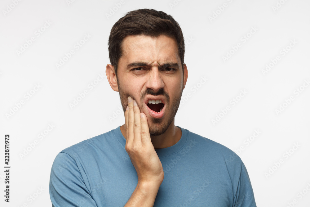 Toothache concept. Closeup of young man isolated on gray background ...