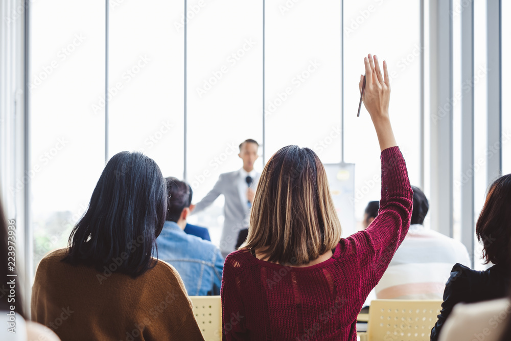 Business woman raising hand for asking speaker for question and answer ...