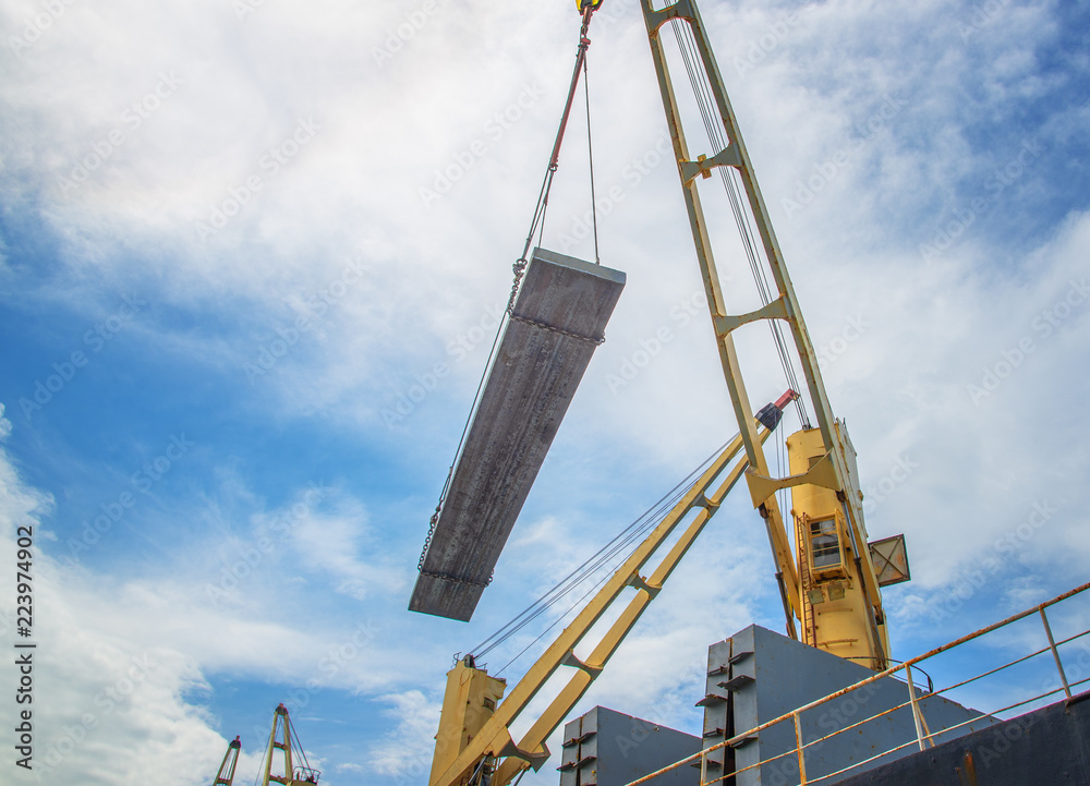 plate of steel slab being lifting handle by the ship crane, loading ...