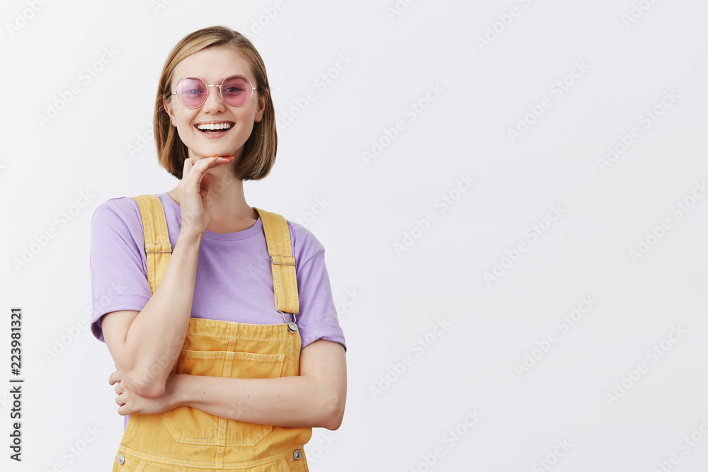 Cute female magazine editor in trendy sunglasses and yellow overalls ...
