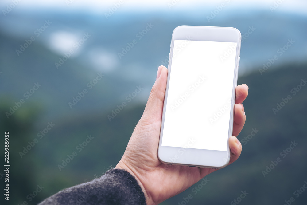 Mockup image of a hand holding and showing white smart phone with blank ...