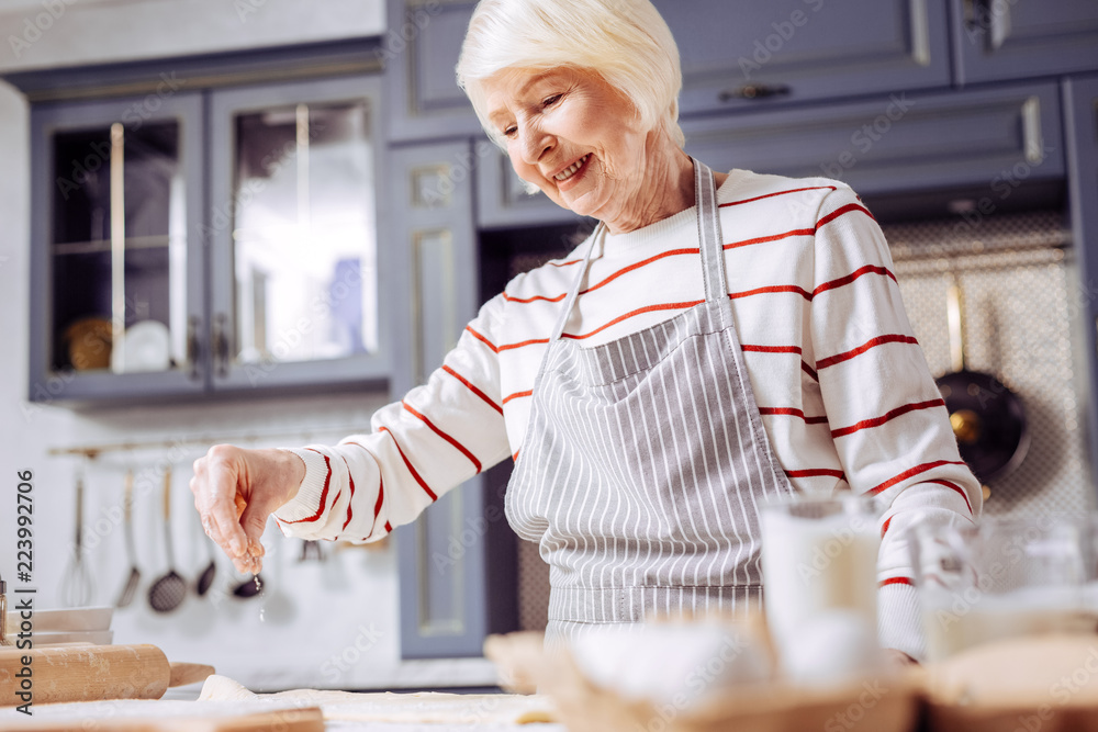 Positive grandma. Cheerful enthusiastic grandmother cooking in the ...