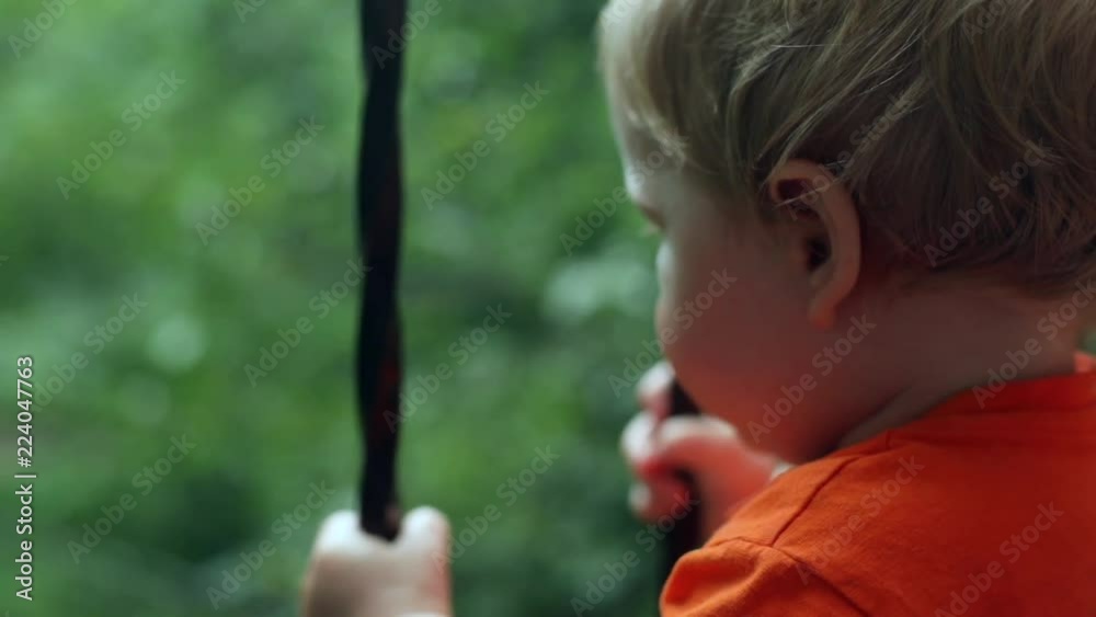 back view of little baby boy with blonde hair standing outside and ...