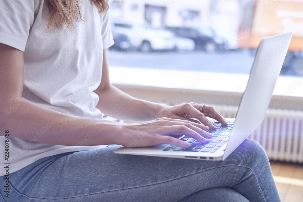 Opened laptop on woman knees, hands on keyboard, space for design ...