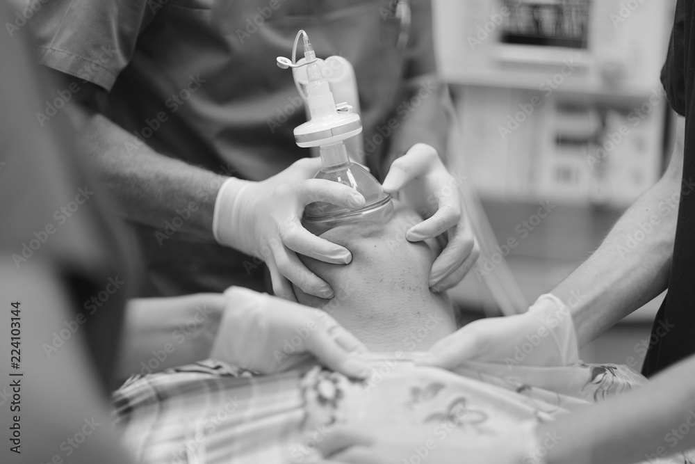 An anesthesiologist leads the patient into general anesthesia before ...