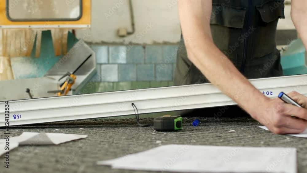 Production and manufacturing of pvc windows, a male worker is measuring ...