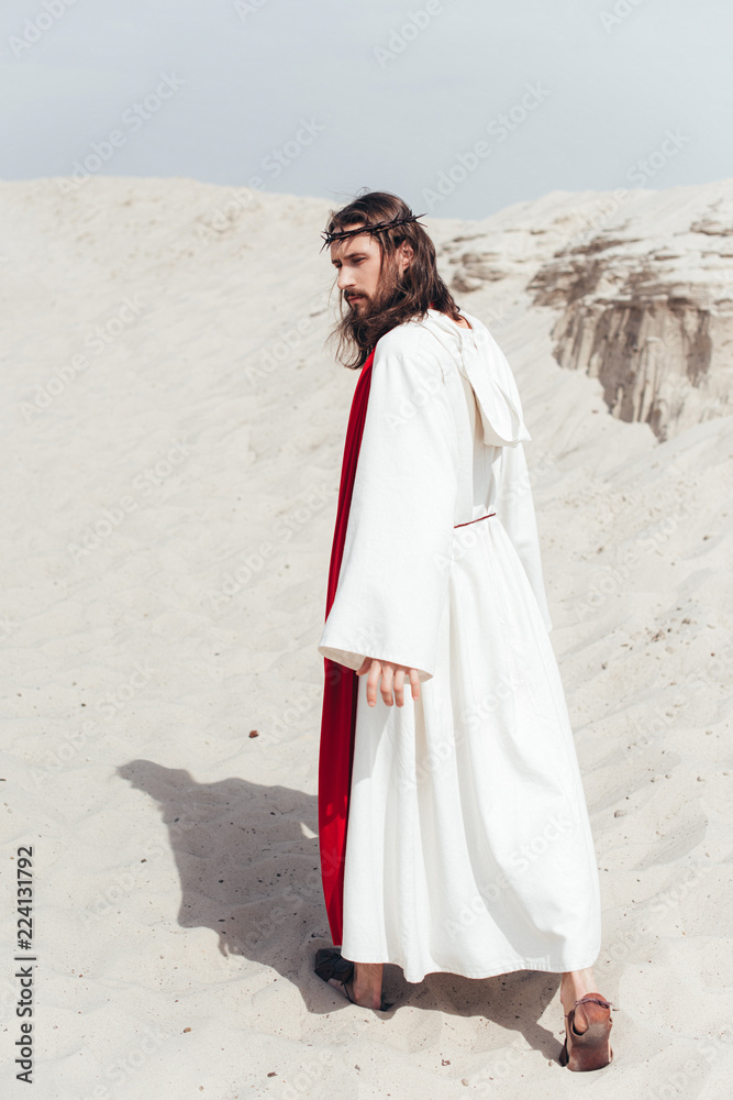 back view of Jesus in robe, red sash and crown of thorns walking in ...