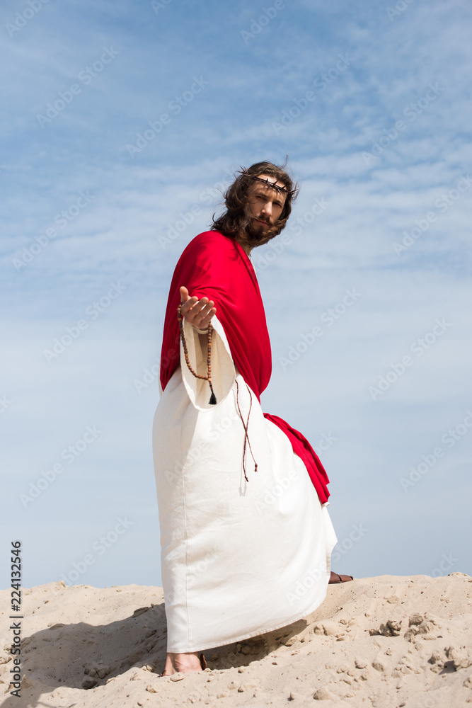 Jesus in robe, red sash and crown of thorns holding rosary and giving ...